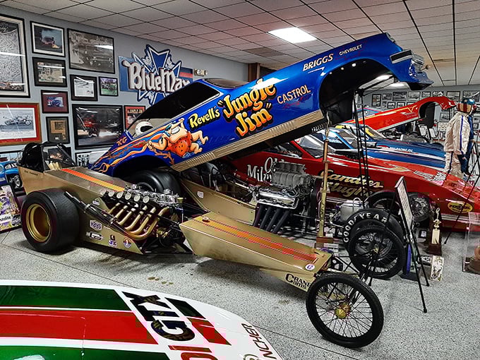 Vintage drag machines rest in formation, their colorful liveries and exposed engines telling tales of quarter-mile glory.