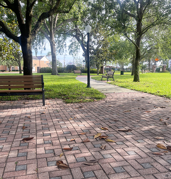 Brick-paved walking paths meander through the park, offering peaceful strolls under the watchful gaze of century-old oak trees dripping with Spanish moss.