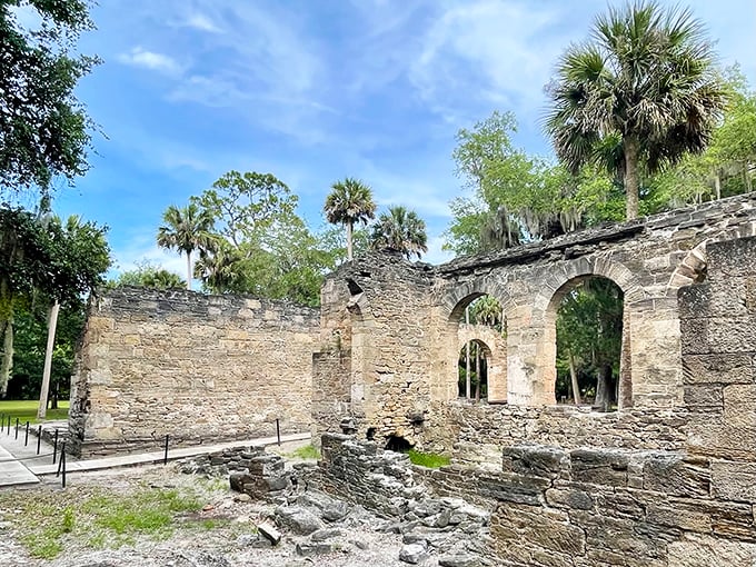 Stone arches frame patches of blue sky where a roof once stood, nature's perfect picture frame for this sugar mill's second life as a historical ruin.