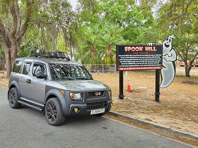 Spook Hill's whimsical sign invites skeptics and believers alike to experience a gravity-defying phenomenon that's been puzzling visitors for generations.
