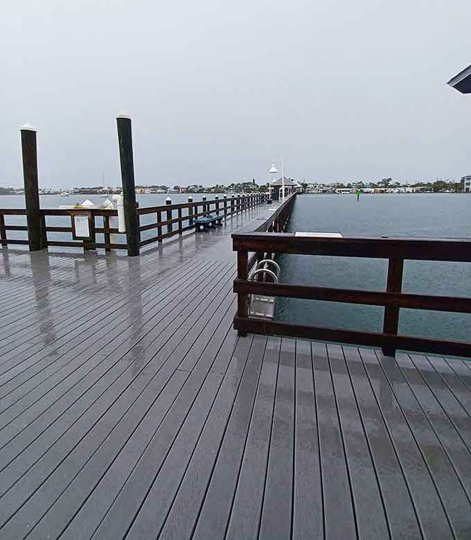 Looking down the wooden planks of Bradenton's pier on a cloudy day, history whispers from every board.