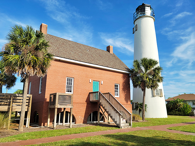 The impressive height of Cape St. George Light is showcased against puffy white clouds, its bold white color making it visible to sailors miles offshore.