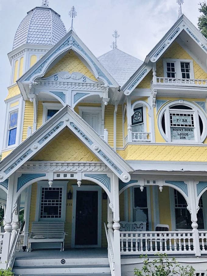 That porch wraps around like a welcoming hug, though some visitors report the hugs occasionally come from sources they can't quite see.