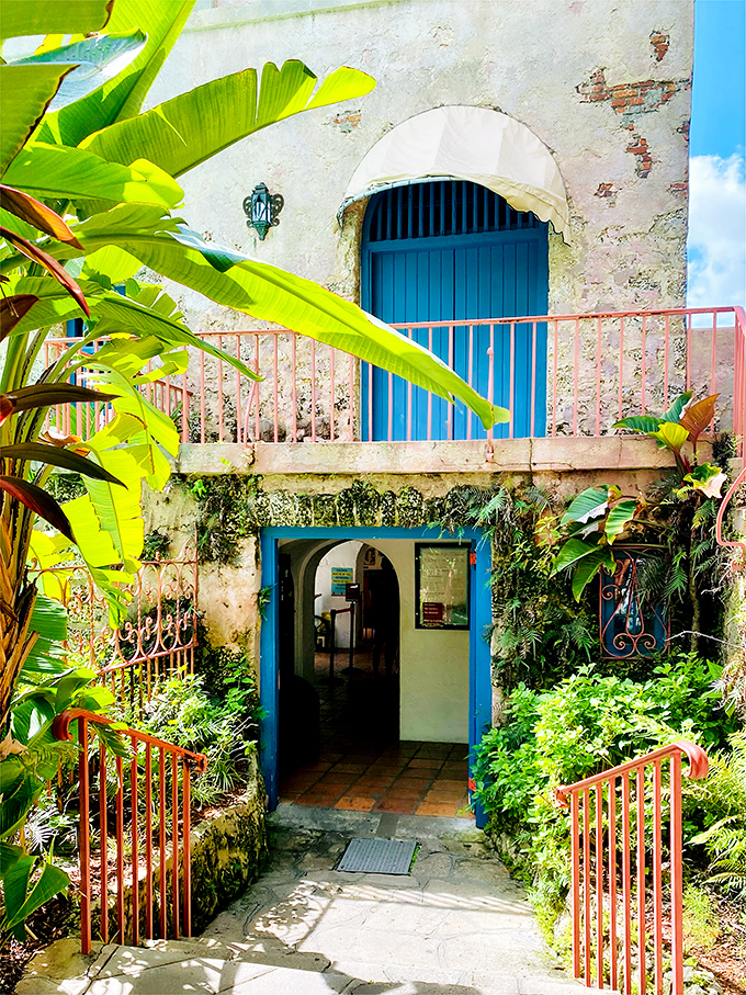 Blue doors frame the entrance like a portal to another era, where Mediterranean charm meets Florida sunshine.