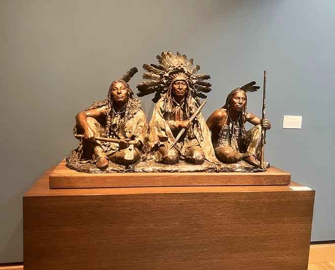 Three figures captured in bronze tell a story of community and tradition, frozen in time but somehow still alive.