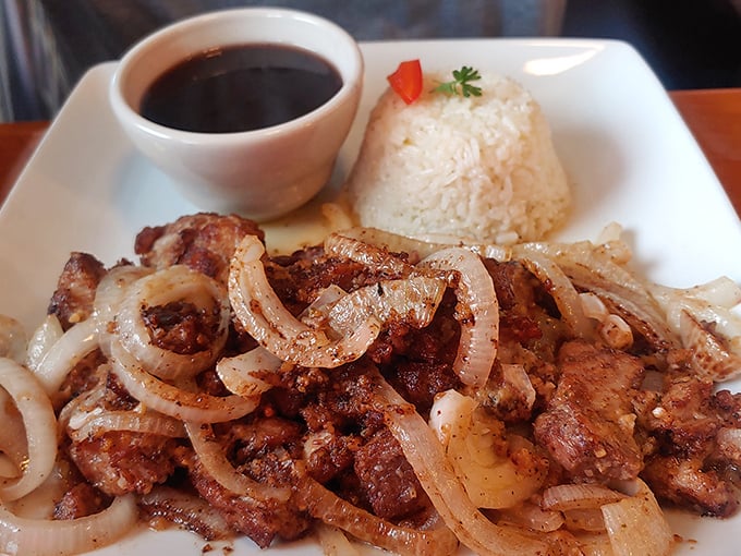 Masitas De Puerco &ndash; tender pork chunks with caramelized edges served alongside perfectly cooked rice and savory black beans.