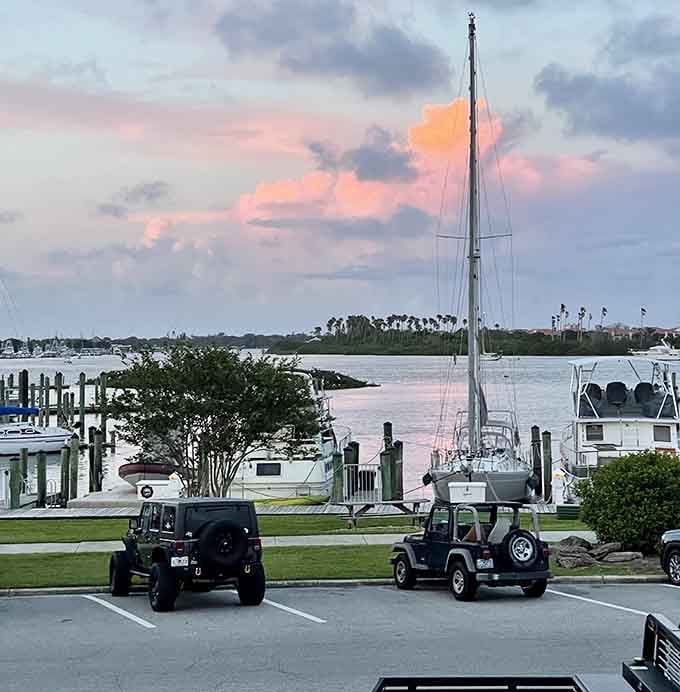 That parking lot view hits different when sailboats and sunset colors are part of the package, and yes, the parking is actually free.