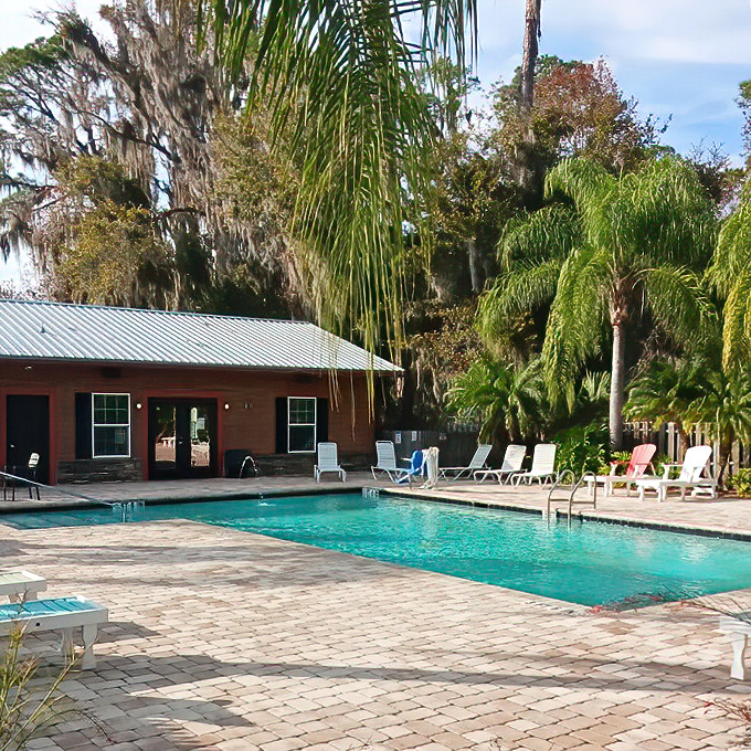 Crystal-clear waters invite swimmers to escape the Florida heat, with palm-fringed poolside lounging areas promising post-dip relaxation.