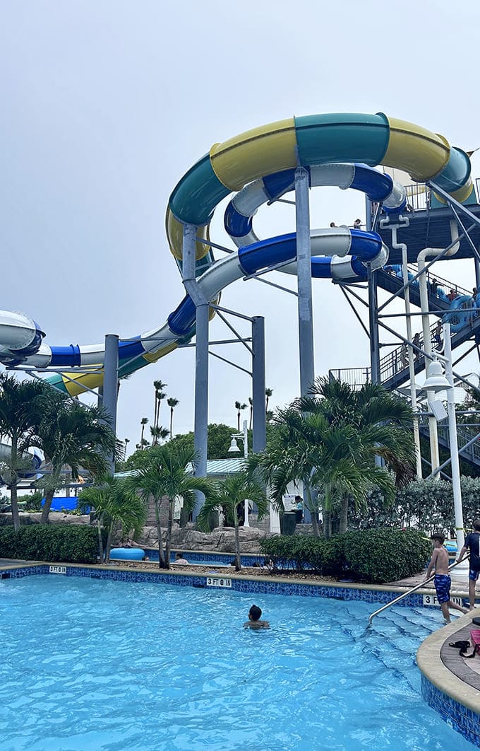 The main pool area sprawls beneath those magnificent slides, creating a splash zone where physics meets fun and everyone gets soaked.