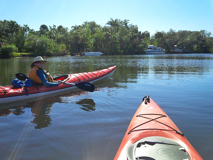 Two paddlers sharing stories on sun-dappled waters &ndash; because the best conversations happen when there's no WiFi, just ripples and reflections.