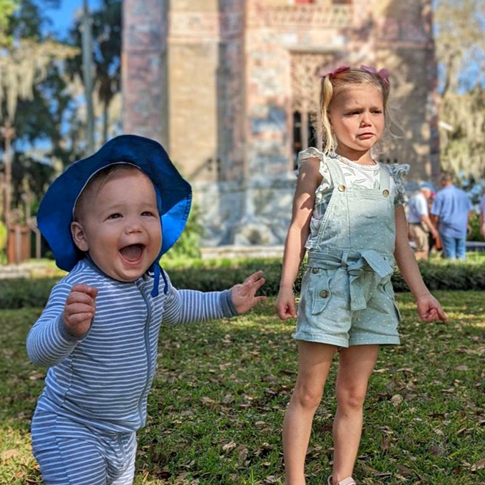 Little explorers discovering the gardens' magic &ndash; one child's pure joy contrasting perfectly with the other's "are we done yet?" expression.