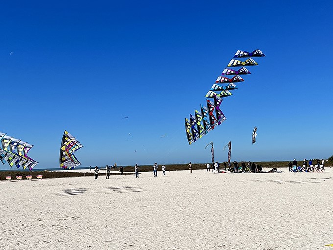 Geometric kites create a mesmerizing formation against the cloudless sky, showcasing why Treasure Island has become a kite-flying mecca.