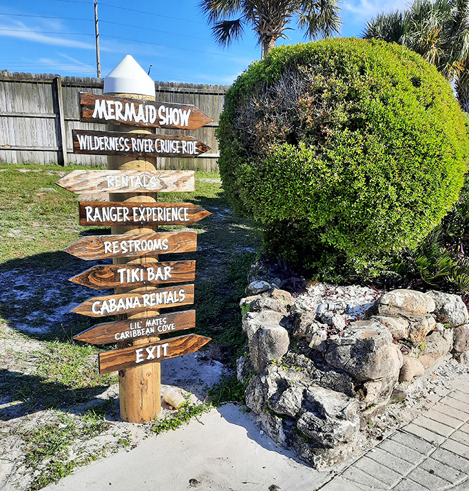 Rustic signpost points the way to magical experiences - mermaids, river cruises, and tiki refreshments await adventurous visitors.