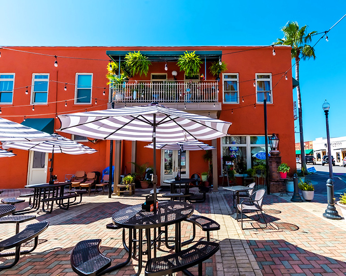 Millie's coral-red building stands out like a beacon for seafood lovers. The outdoor patio with striped umbrellas creates the perfect spot for people-watching.