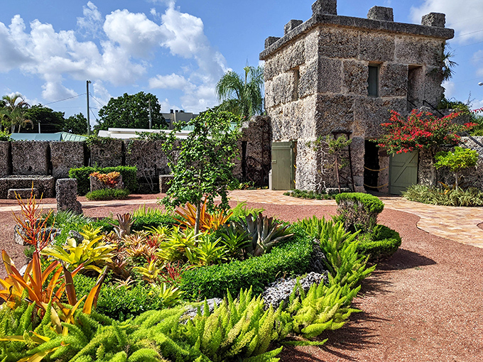 The meticulously maintained gardens surrounding Coral Castle's stone buildings create a peaceful oasis that enhances the site's otherworldly atmosphere.