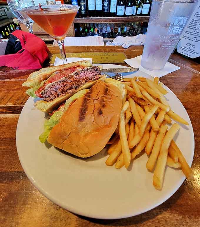 A generously portioned sandwich with golden fries and a colorful cocktail proves that Bobby's understands the assignment when it comes to satisfying meals.