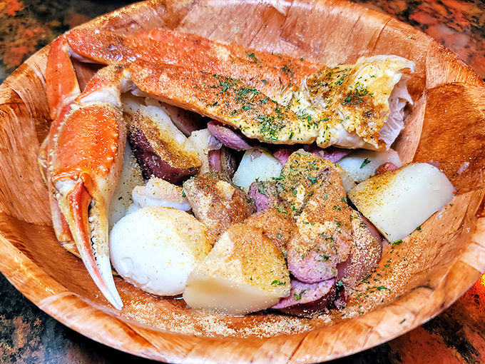 This wooden vessel cradles sweet crab meat and potatoes, creating a rustic seafood experience that makes fancy china seem utterly pointless.