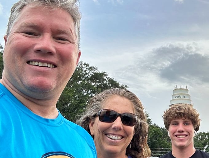 Happy visitors capturing that perfect family selfie with Florida's sweetest landmark &ndash; proving the cake tower brings out smiles as reliably as actual dessert.