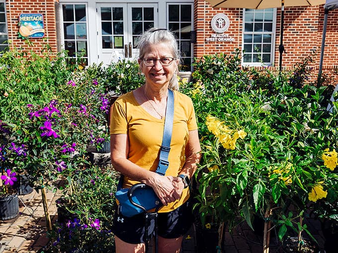 Festival-goers stroll through displays of vibrant blooms, their smiles suggesting they've found their happy place among the petunias and perennials.