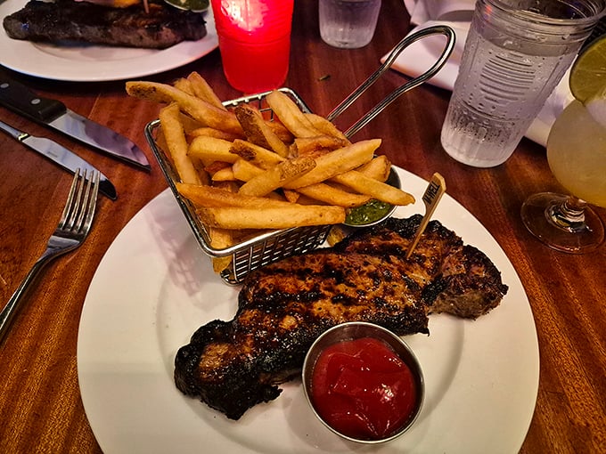 Perfectly grilled steak served alongside golden fries &ndash; simple pleasures elevated to art form in this industrial-chic setting.