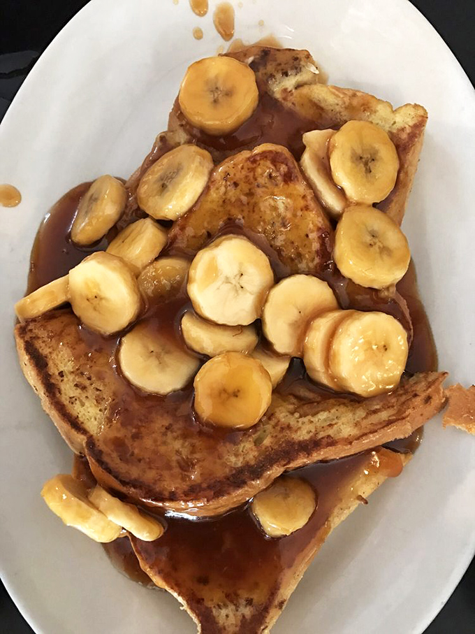 Challah French toast elevated to art form, with caramelized bananas and a maple syrup pool that would make swimmers jealous.
