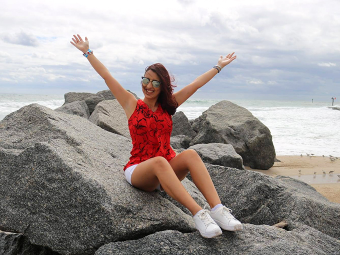 Pure joy captured on the rocks! Nothing says "I'm living my best Florida life" like celebrating with arms wide open by this historic beacon.