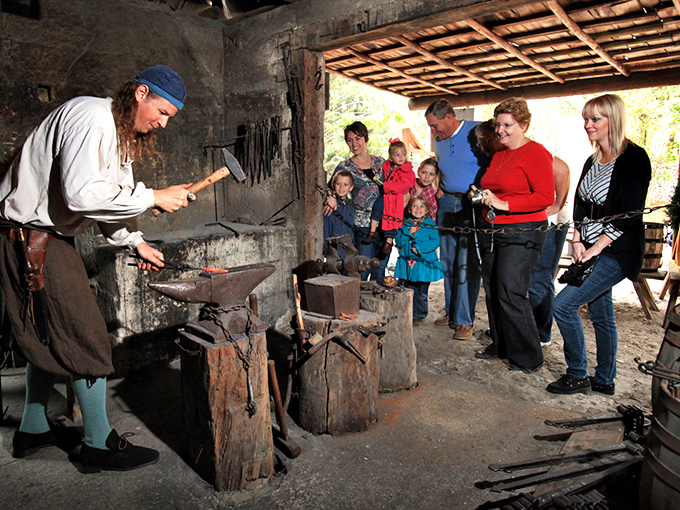 The blacksmith demonstrates ancient metalworking while visitors realize their office complaints suddenly seem rather trivial.