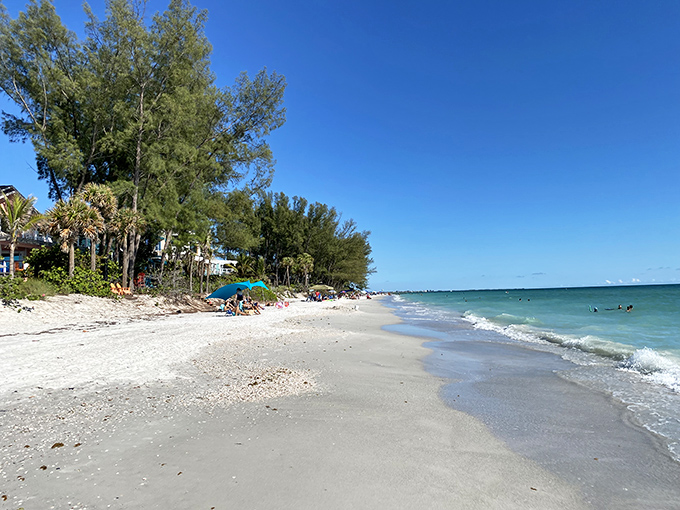 The pristine white sands of Treasure Island stretch toward gentle waves, inviting barefoot wanderers to leave footprints along the shoreline.
