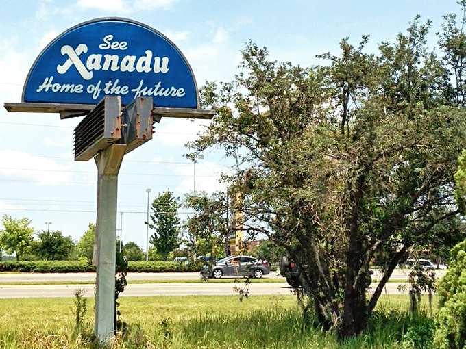 The bright blue "Xanadu" sign stands like a retro UFO against the Florida sky, still proudly advertising tomorrow's home long after yesterday's future was canceled.