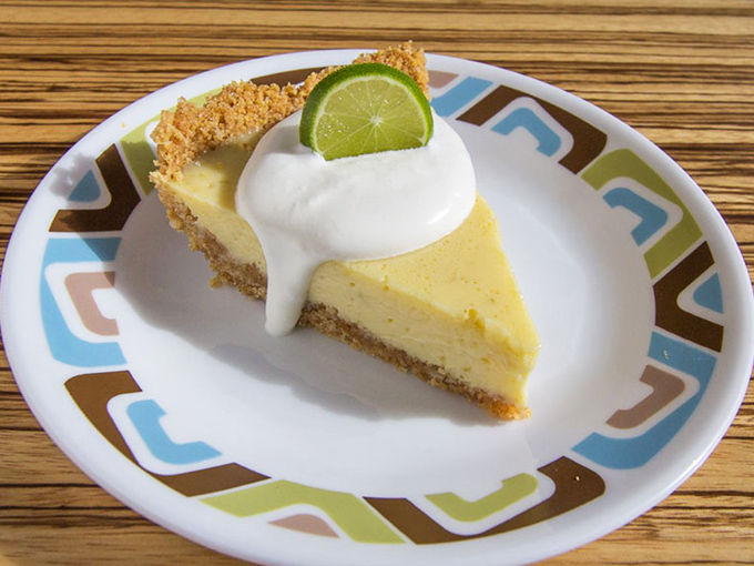 A slice of authentic Key Lime pie is Florida sunshine on a plate – tangy, sweet, and topped with a cloud of fresh whipped cream.