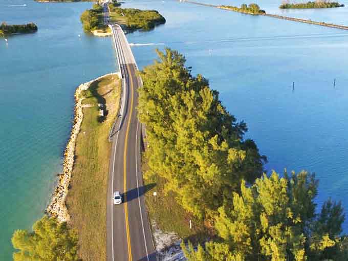 The causeway cuts through bright blue water, connecting land masses in a scene that looks too perfect to be real.