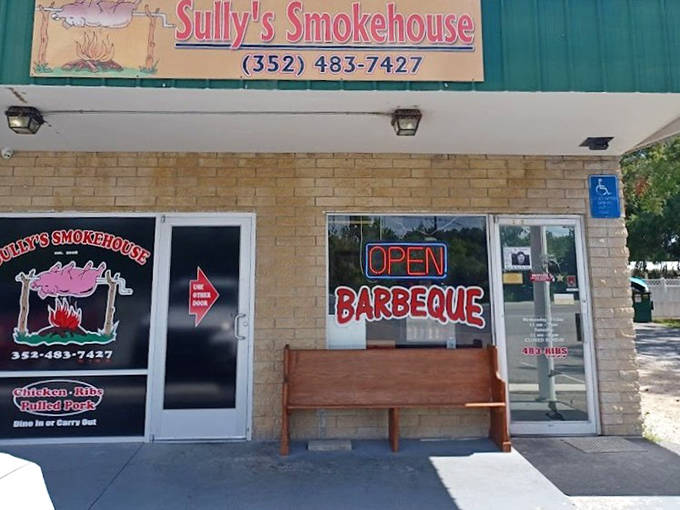 Sully's Smokehouse announces itself with a straightforward brick exterior and neon "OPEN" sign that BBQ lovers recognize as a beacon of deliciousness.