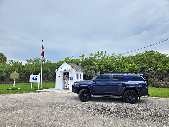 A visitor's SUV dwarfs the tiny Ochopee Post Office, highlighting just how remarkably small this fully-functioning postal facility really is.