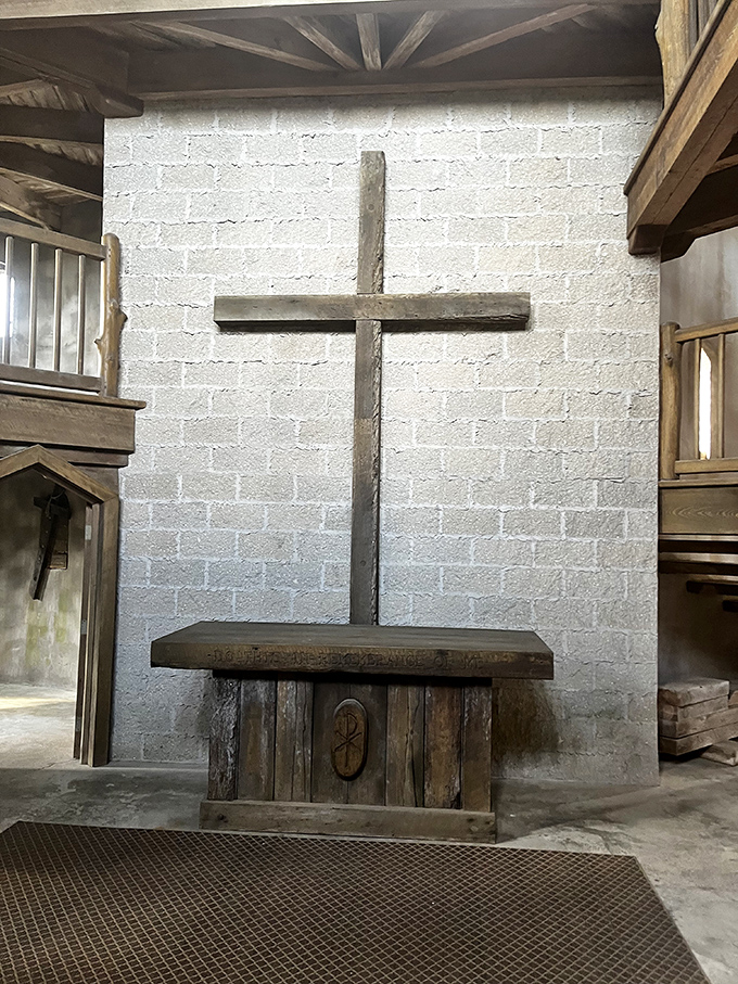 The altar's rustic simplicity speaks volumes, a wooden whisper of faith amid fortress-thick walls.