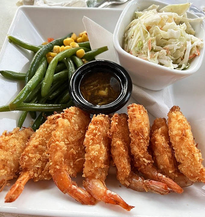 Golden-armored shrimp stand at attention beside vibrant green beans, like delicious sentinels guarding that tangy dipping sauce.