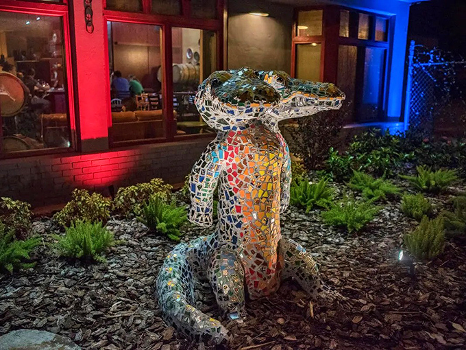 By night, the mosaic gator transforms into a glittering sentinel, its colorful scales catching the restaurant's warm glow.