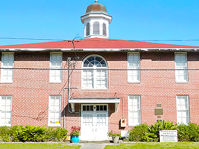 Morning light bathes the Old Lutz Schoolhouse in golden warmth, highlighting its symmetrical design and welcoming entrance.