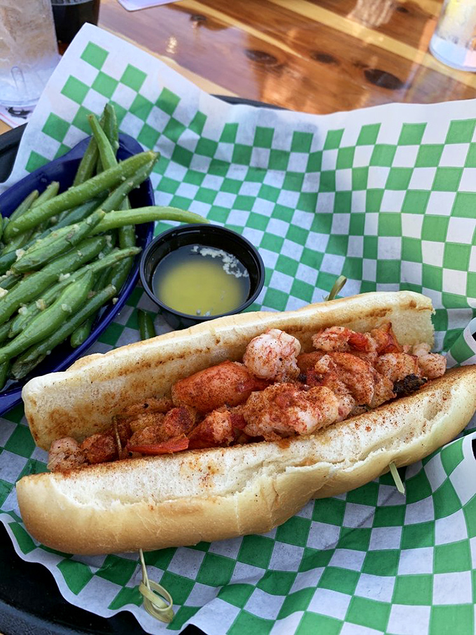 This lobster roll isn't just a sandwich; it's a buttery throne for sweet chunks of Maine's finest, escorted by vibrant green beans.