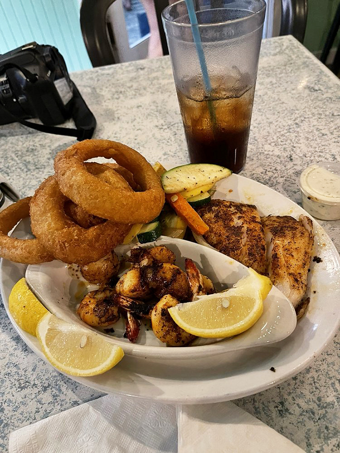 A seafood medley that would make Neptune jealous &ndash; grilled fish, plump shrimp, and crispy onion rings in perfect harmony.