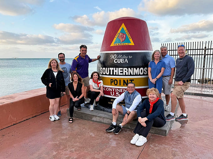 Nothing says "we made it" quite like a group photo with the buoy, proof that family vacations create memories worth framing.