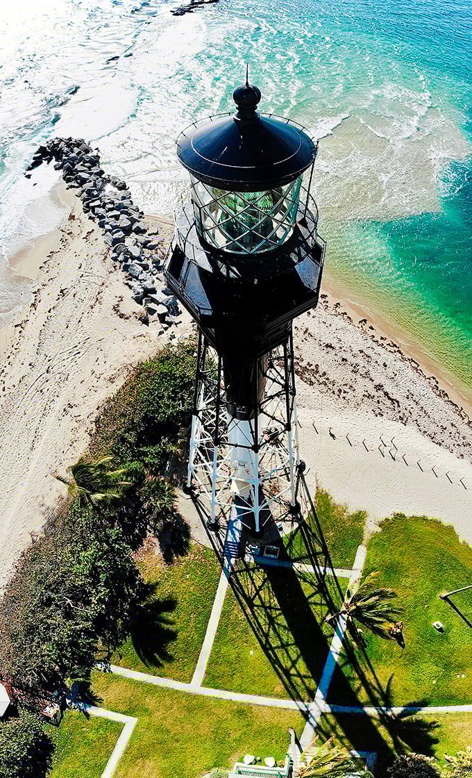 From this bird's-eye perspective, the lighthouse lens gleams like a massive diamond, ready to send its protective beam across miles of treacherous waters.
