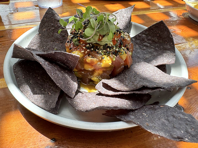 Tuna tartare that's dressed to impress, mingling with avocado and mango while blue corn chips stand ready for scooping duty.