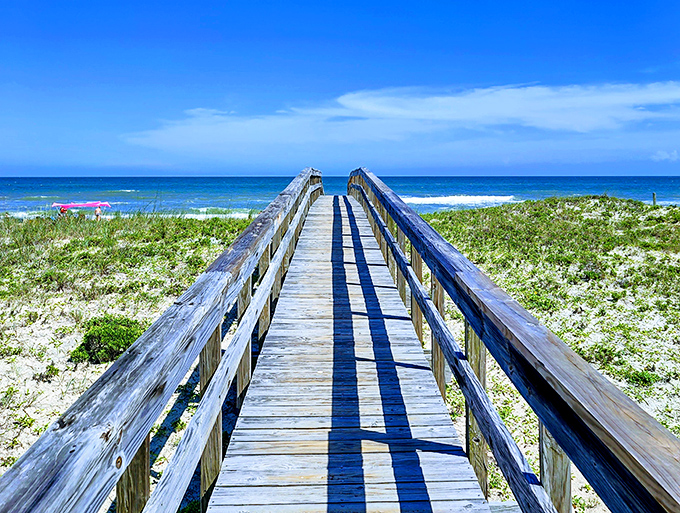 This wooden boardwalk invites you to leave footprints in the sand while protecting the fragile dune ecosystem beneath.