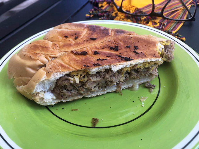 The cross-section reveals the architecture of flavor – notice how the cheese has melted into the meats during the pressing process.