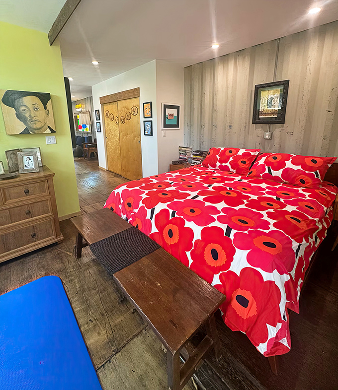 Bold red poppies against crisp white linens create a sleeping space that's part boutique hotel, part modern art installation.