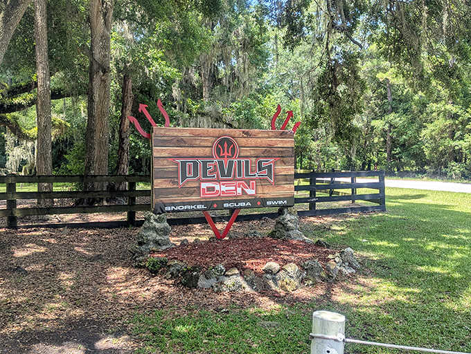 The rustic wooden entrance sign to Devil's Den hints at the natural wonder waiting below ground for adventurous visitors.