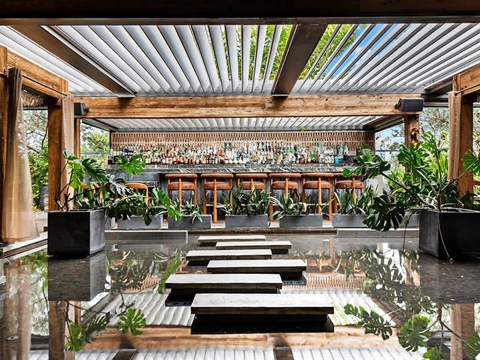 Water features and stepping stones create a zen-like path to MILA's bar. Tropical plants frame the space where Mediterranean meets Asian cuisine.