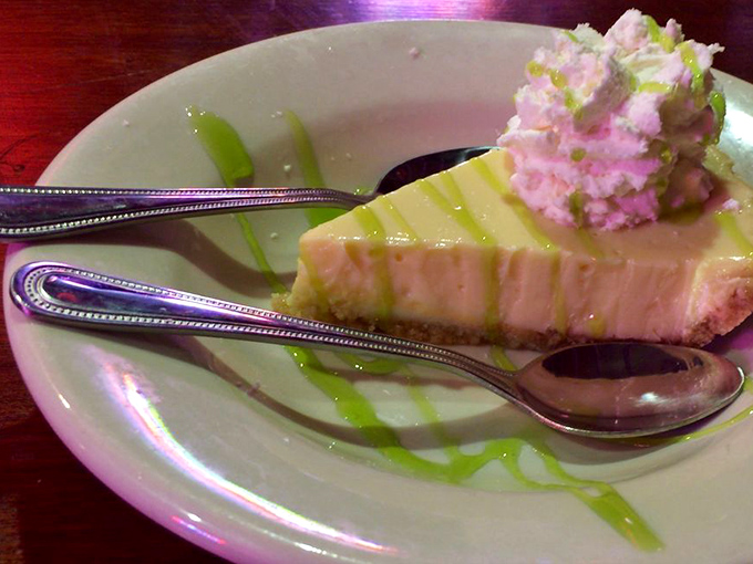 Key lime pie in all its glory &ndash; pale green filling atop graham cracker crust, artfully presented with a zigzag of lime syrup and fresh whipped cream.
