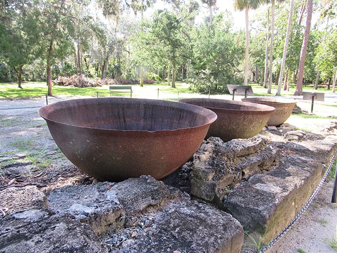 Massive iron kettles once bubbled with sugarcane juice, now serving as rust-covered sculptures commemorating Florida's industrial heritage beautifully.
