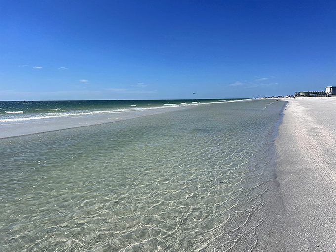 Crystal-clear waters reveal every ripple in the sand beneath, showcasing the remarkable clarity that makes Treasure Island's Gulf waters so irresistible.